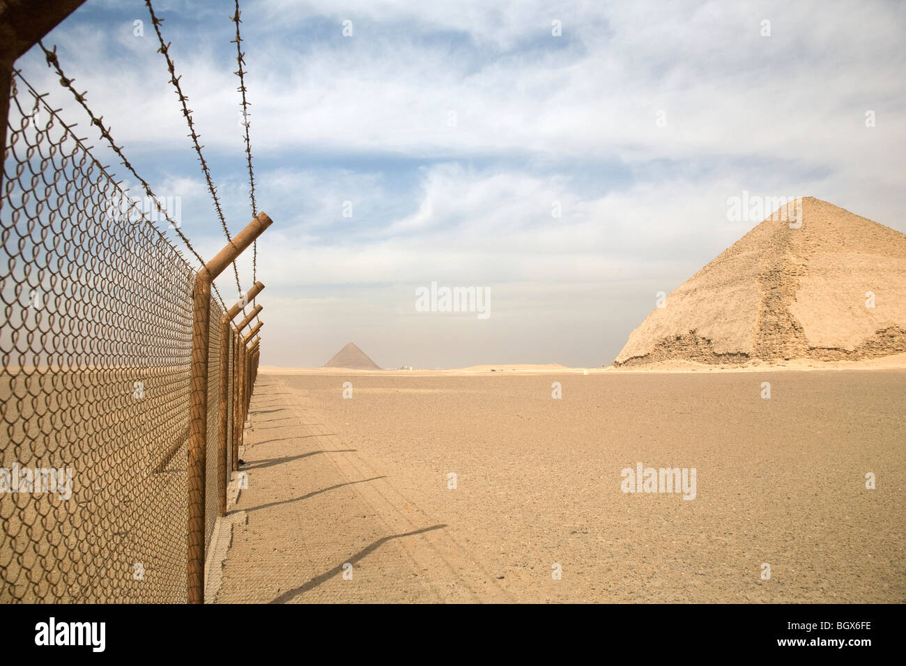 A barbed wire fence by the Bent Pyramid with Pyramid of Giza in ...