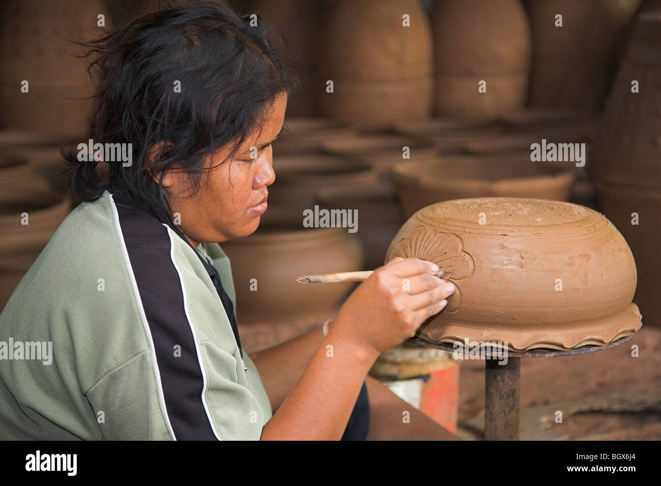 Woman carving pottery Stock Photo - Alamy