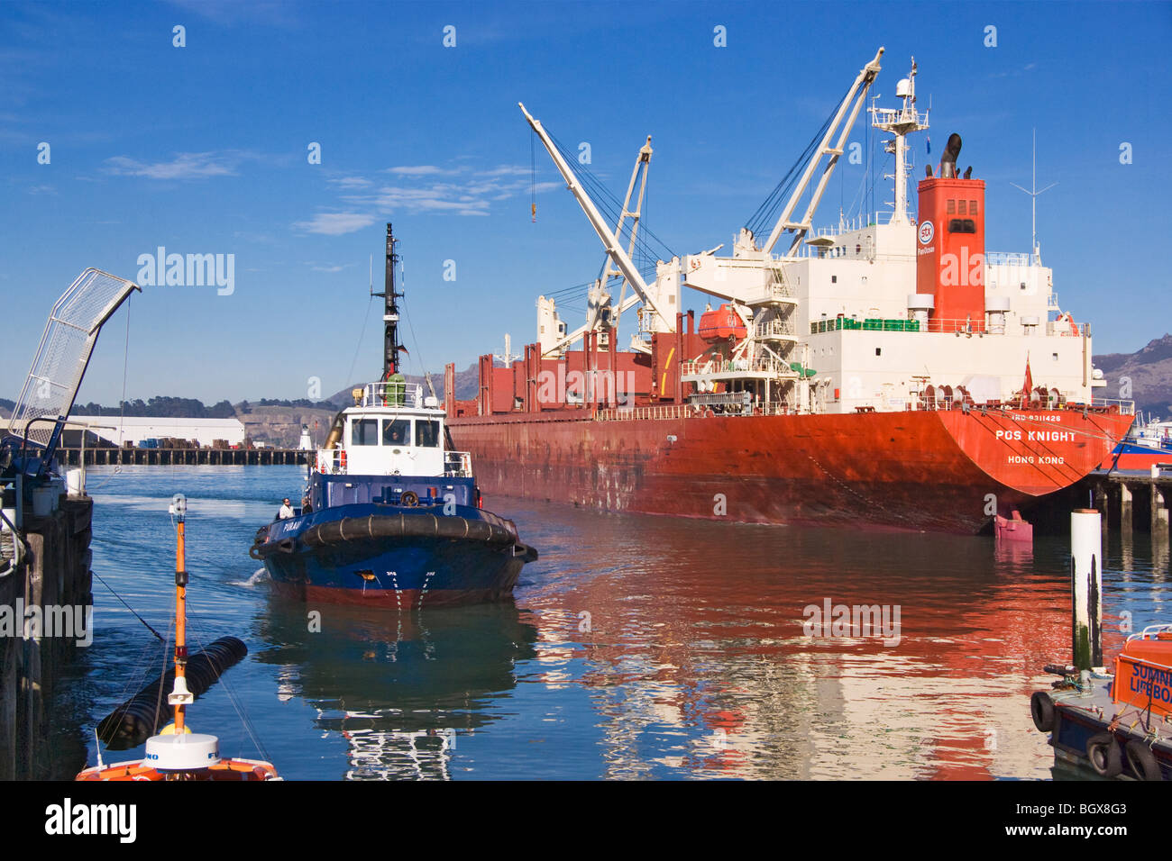 A tug approaches it's berth with a bulk carrier in the background Stock ...