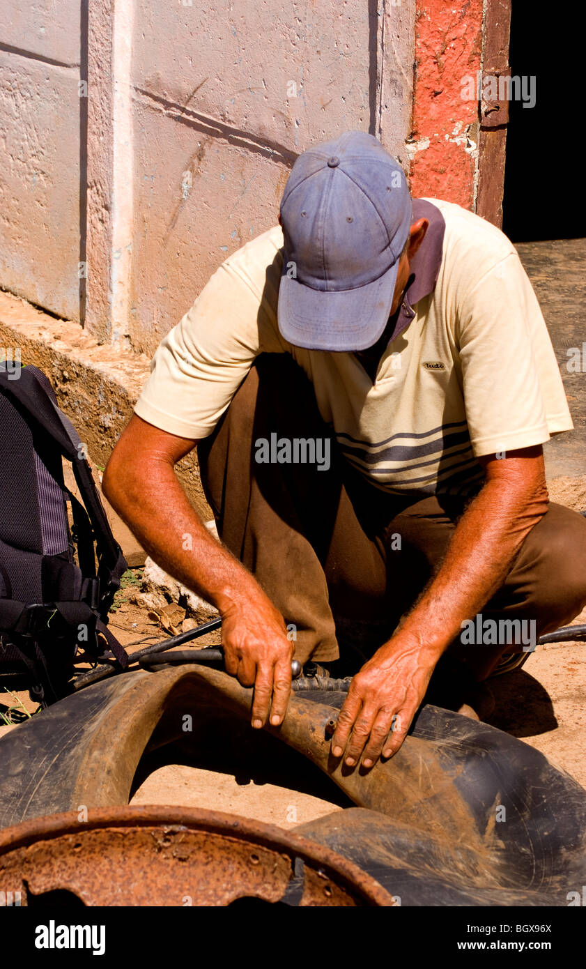 Man repairing flat tire on truck in small village of Australia Cuba ...