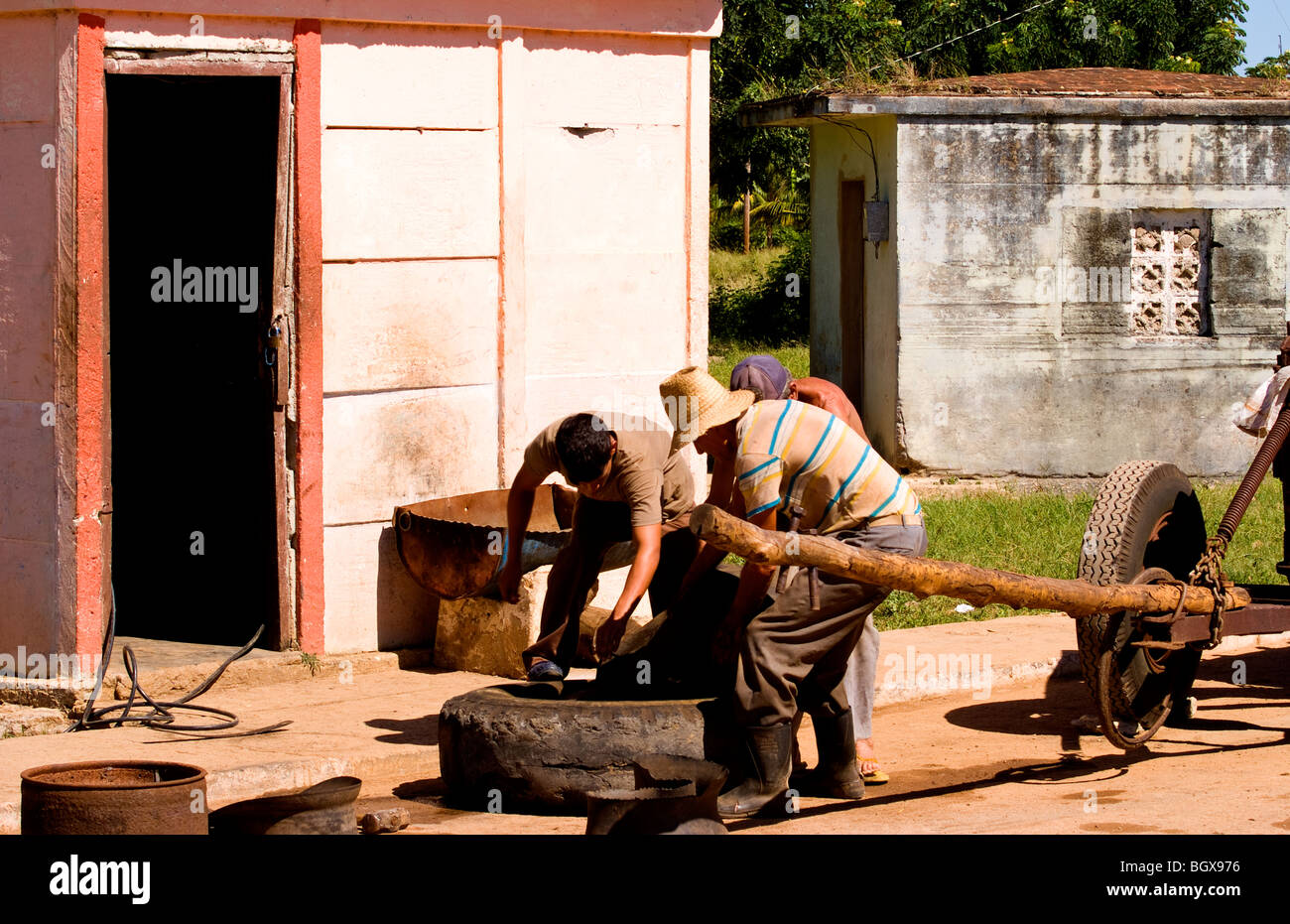 Man repairing flat tire on truck in small village of Australia Cuba ...