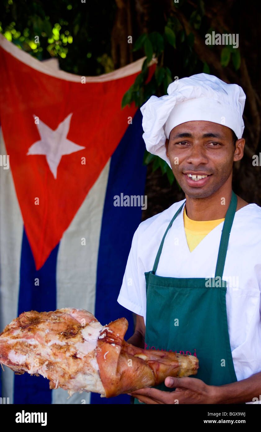 Chef cooking pig in square in Cienfuegos Cuba with Cuban flag Stock ...