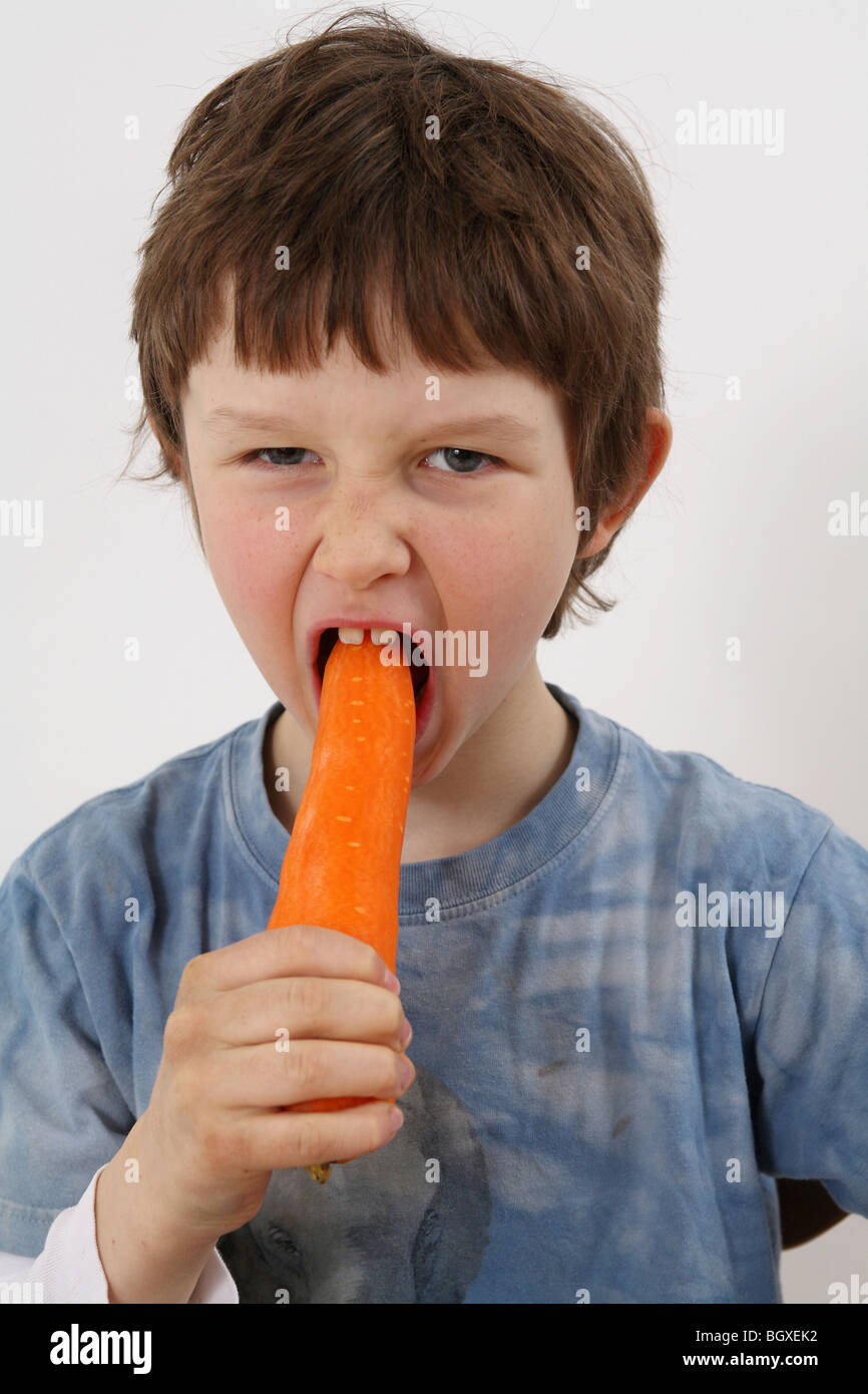 A boy biting a carrot, Berlin, Germany Stock Photo - Alamy