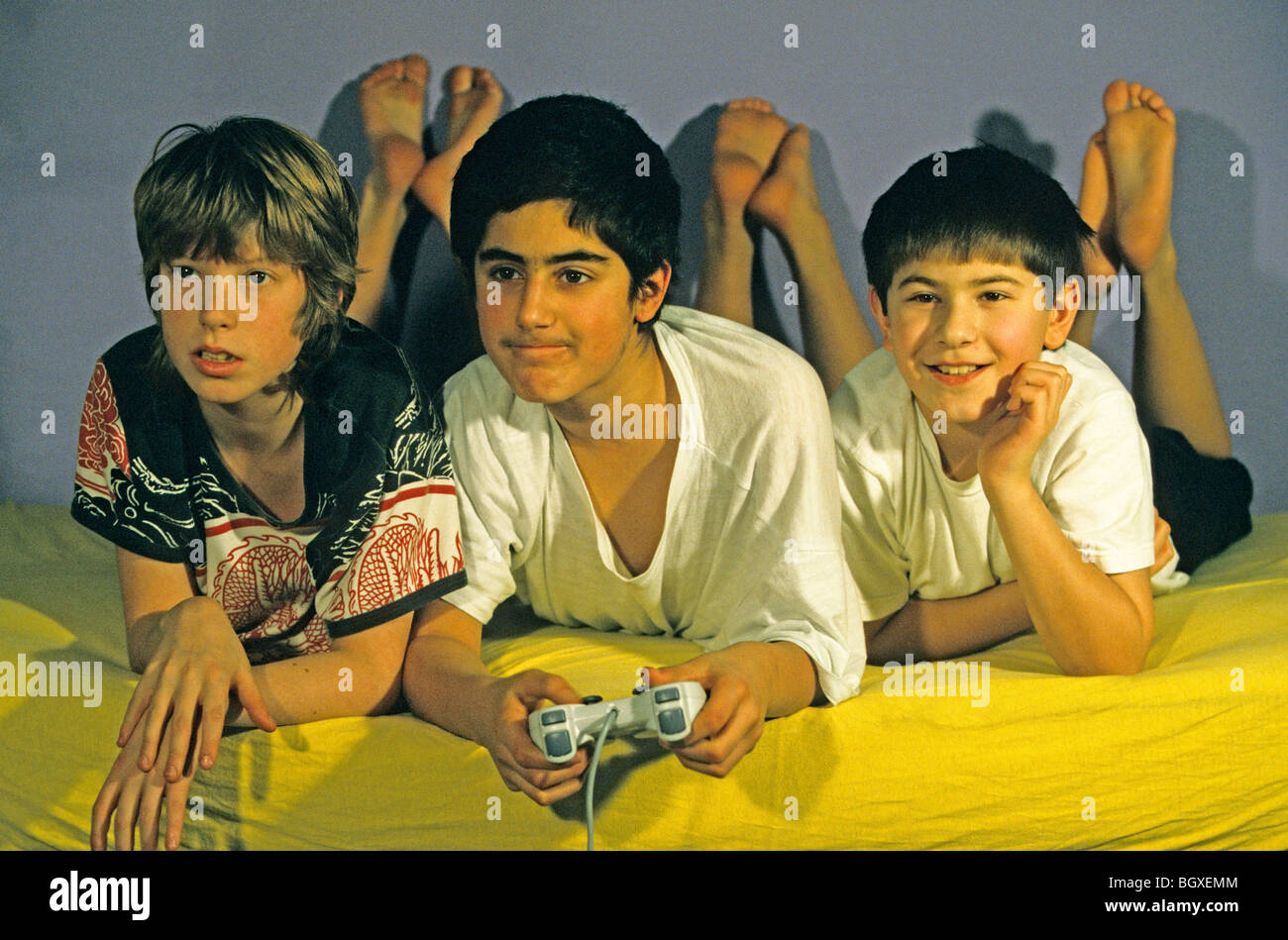 three young boys playing a computer game Stock Photo - Alamy