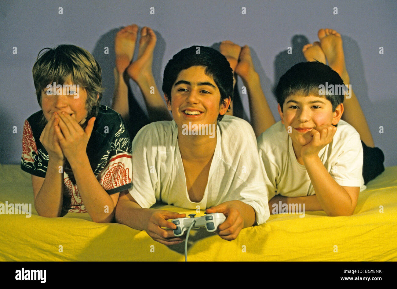 three young boys playing a computer game Stock Photo - Alamy