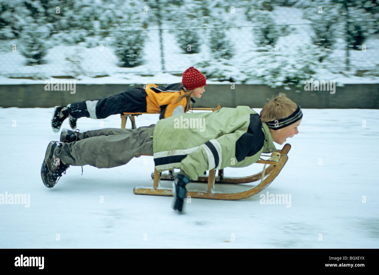 two children tobogganing together Stock Photo - Alamy