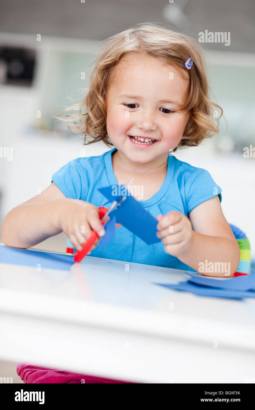young girl using paper and scissors Stock Photo - Alamy