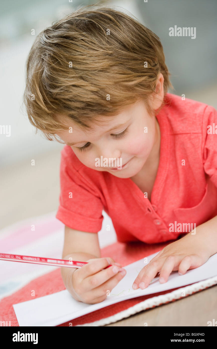 young boy on floor painting with pen Stock Photo - Alamy