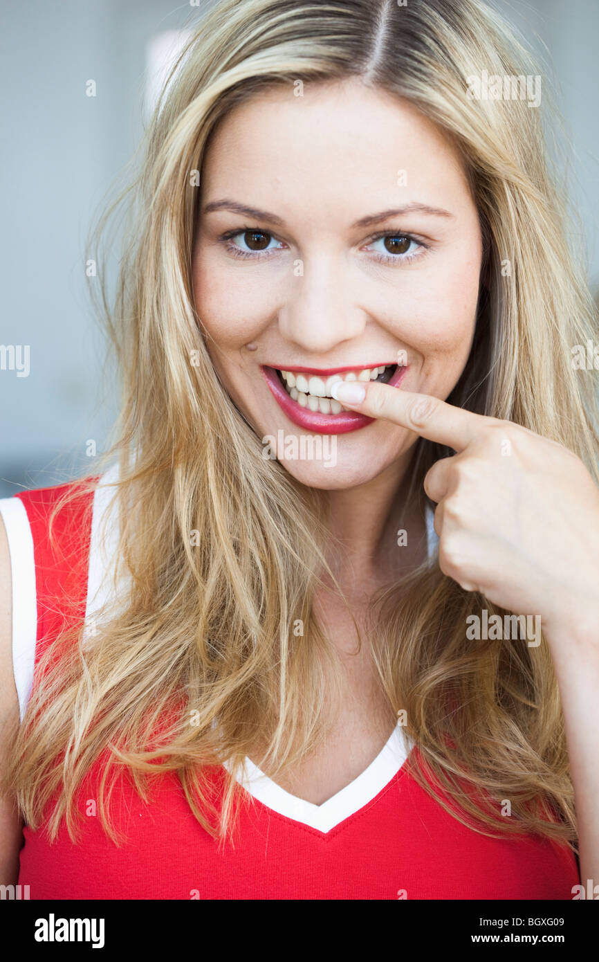 Young woman pointing at her teeth Stock Photo - Alamy