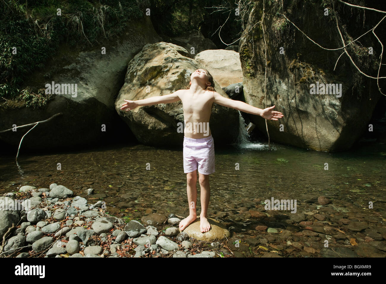 Girl standing on rock in stream Stock Photo - Alamy