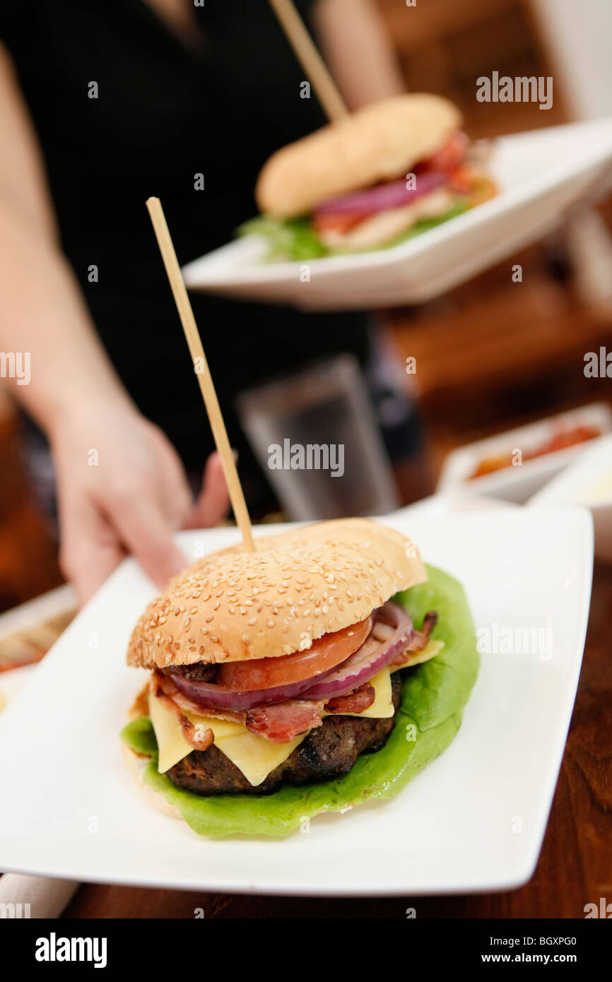 Burger served on a plate in a restaurant Stock Photo - Alamy