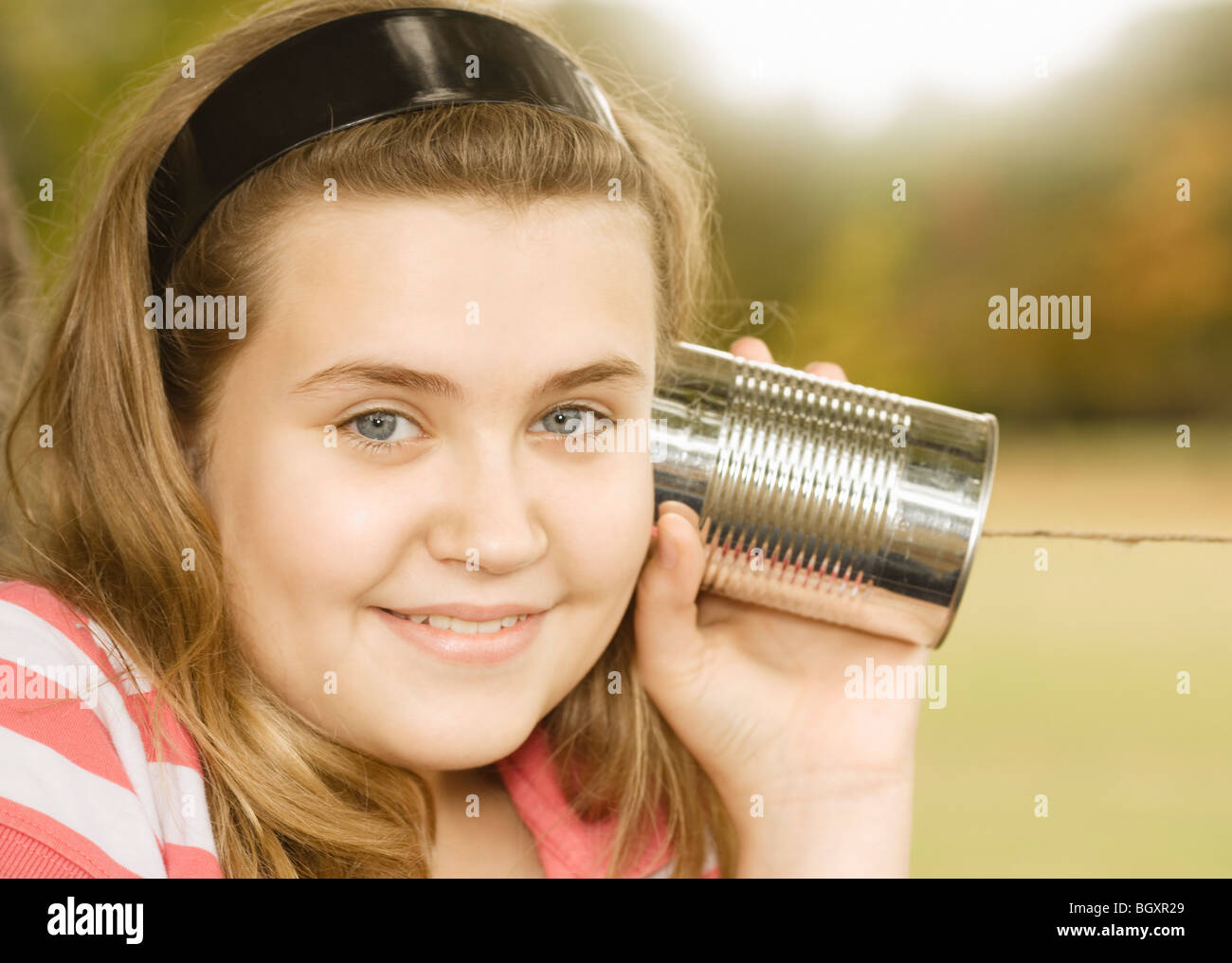 Girl Listening to Tin Can Phone Stock Photo - Alamy