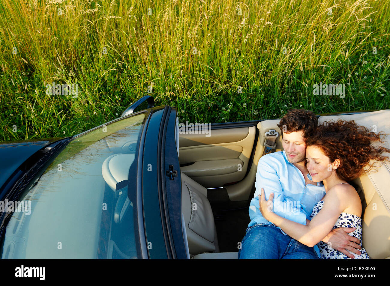 Couple laying in a convertible Stock Photo - Alamy