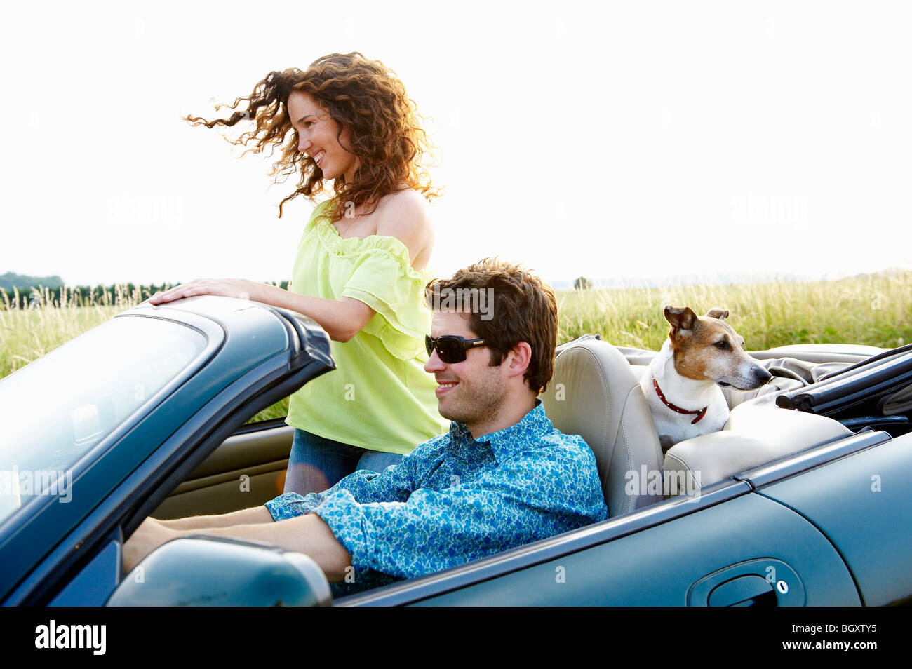 Couple in a convertible, with dog Stock Photo - Alamy