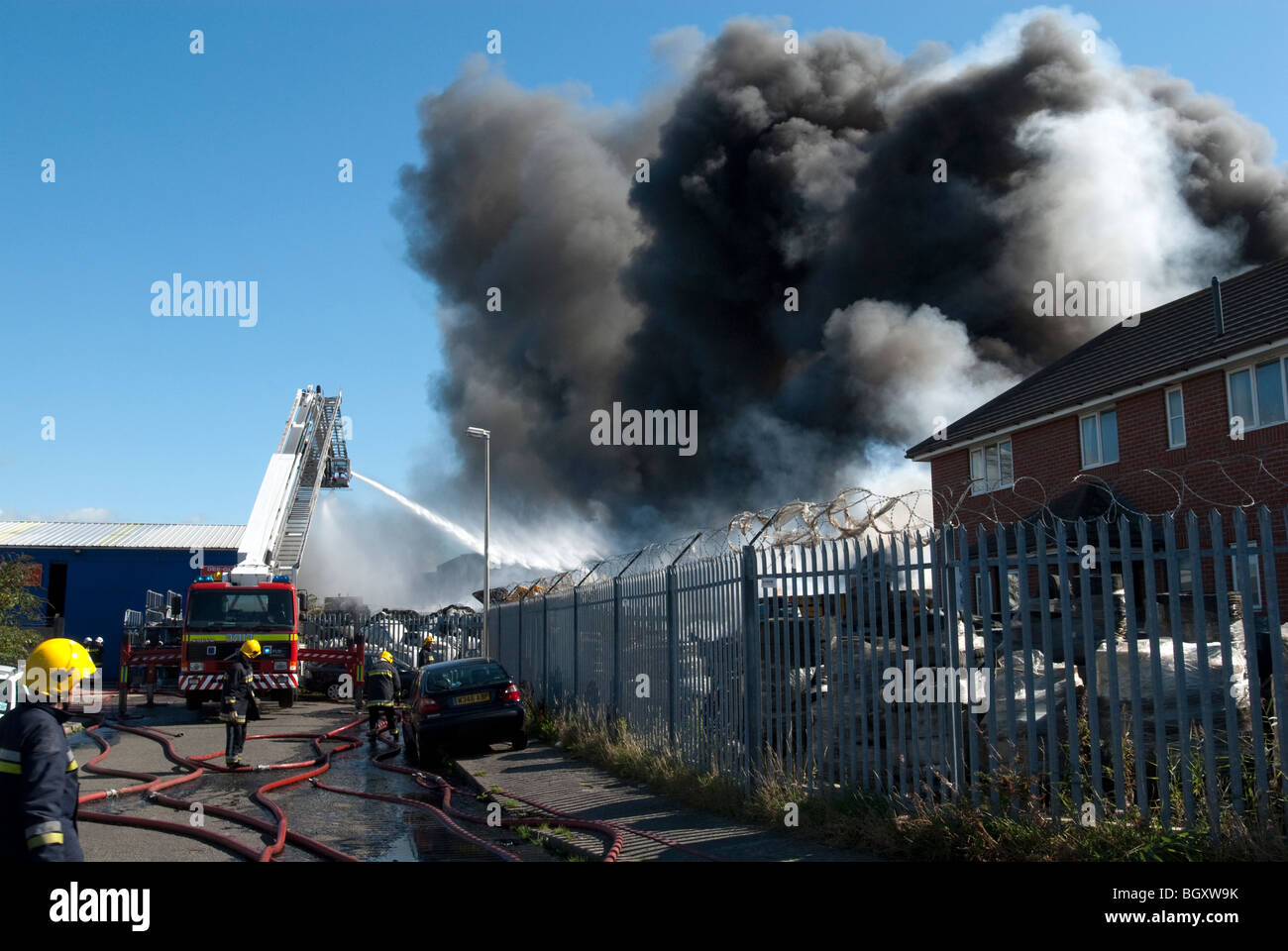 Huge industrial fire with large plumes of thick black smoke against ...