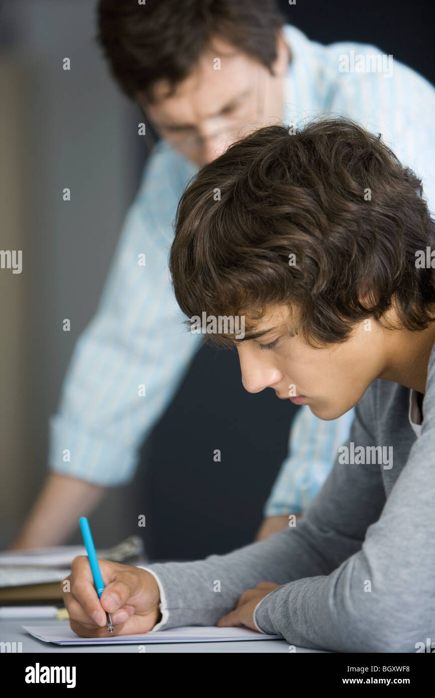 Teacher leaning over student hi-res stock photography and images - Alamy