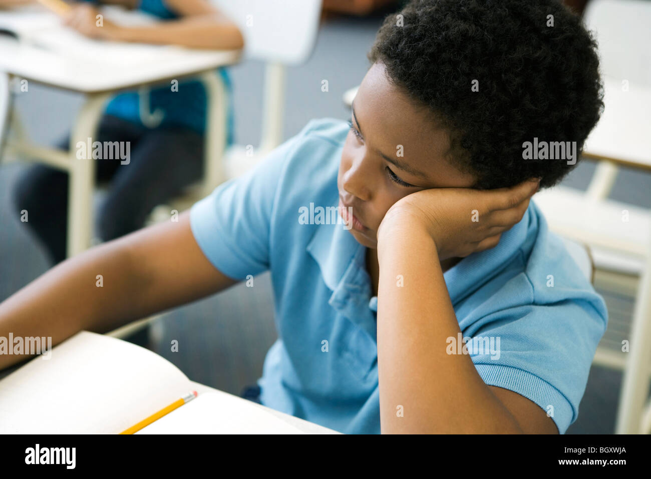 Male elementary school student bored in class Stock Photo - Alamy