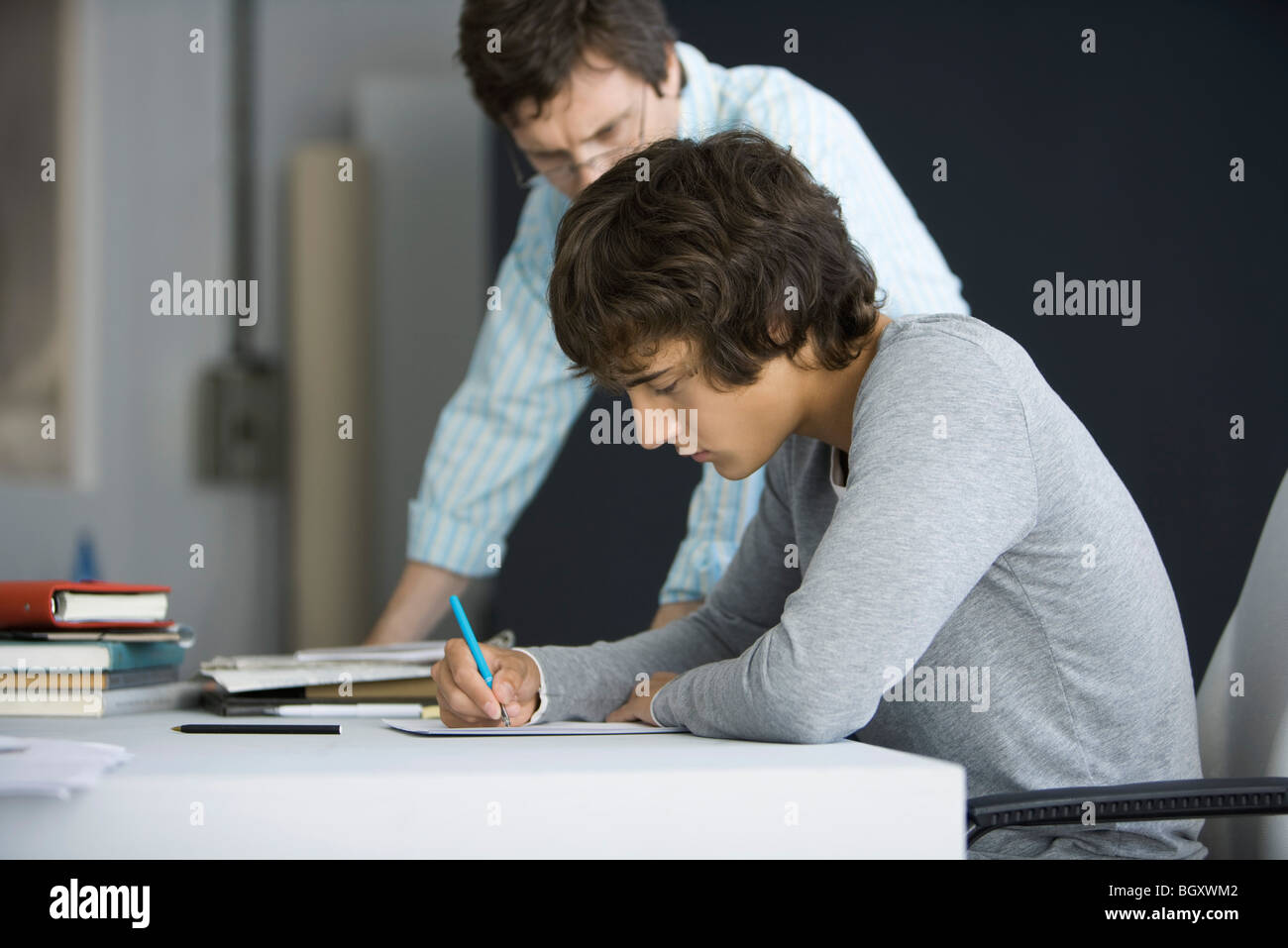 Teacher leaning over desk hi-res stock photography and images - Alamy
