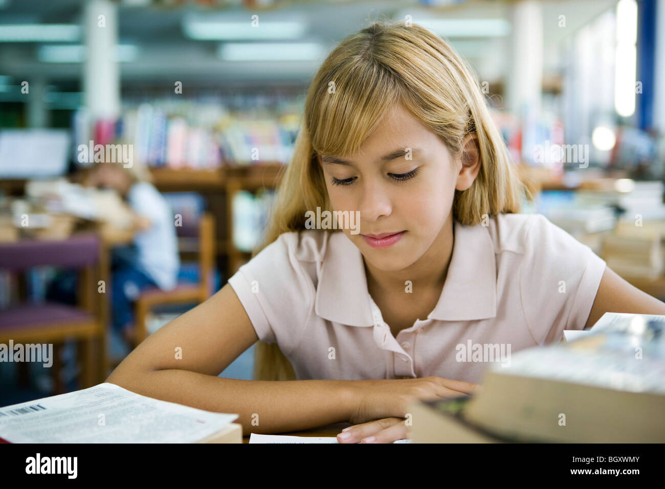 Preteen girl studying in library Stock Photo - Alamy