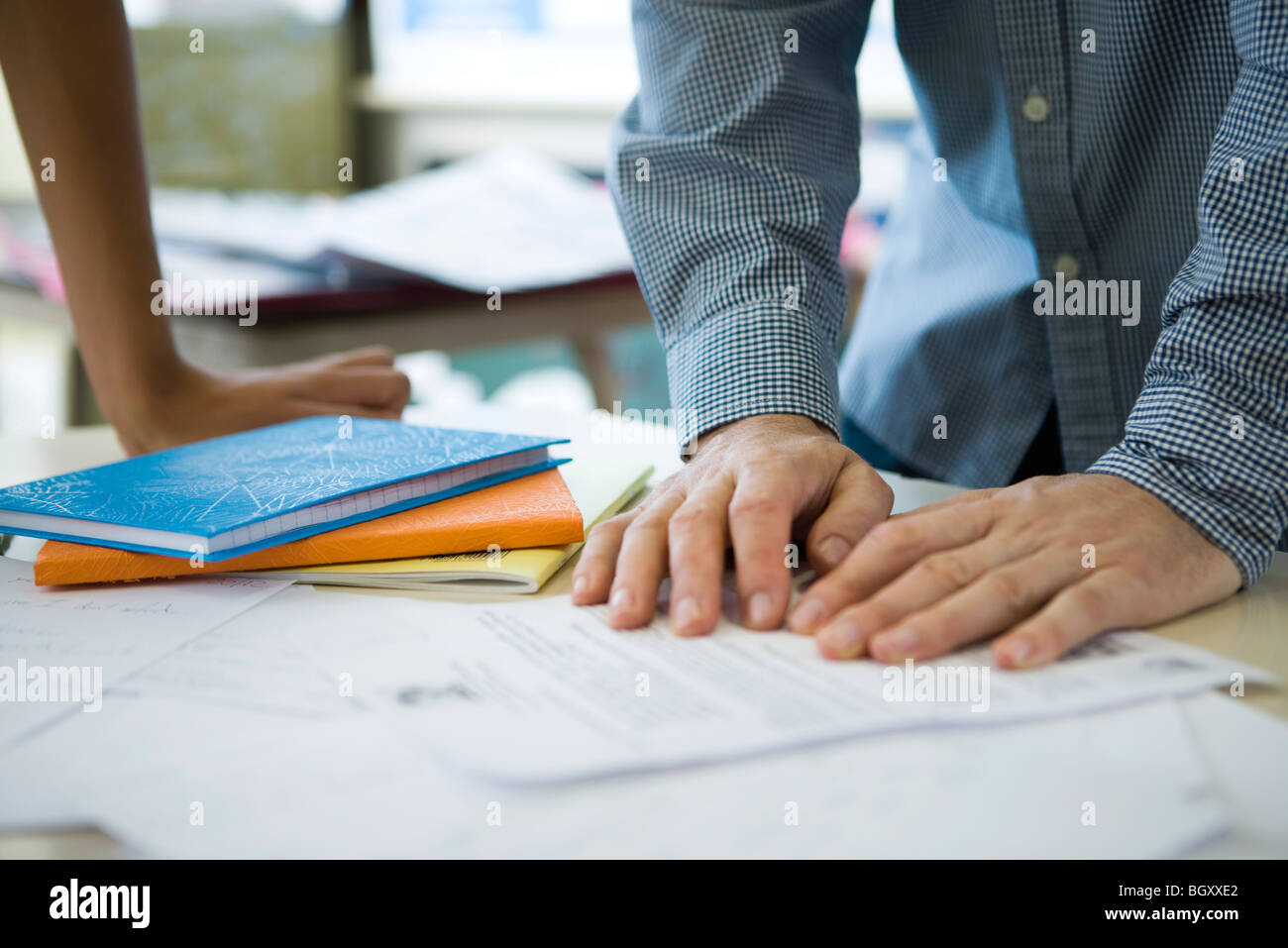 Man leaning over table reading document, cropped Stock Photo - Alamy