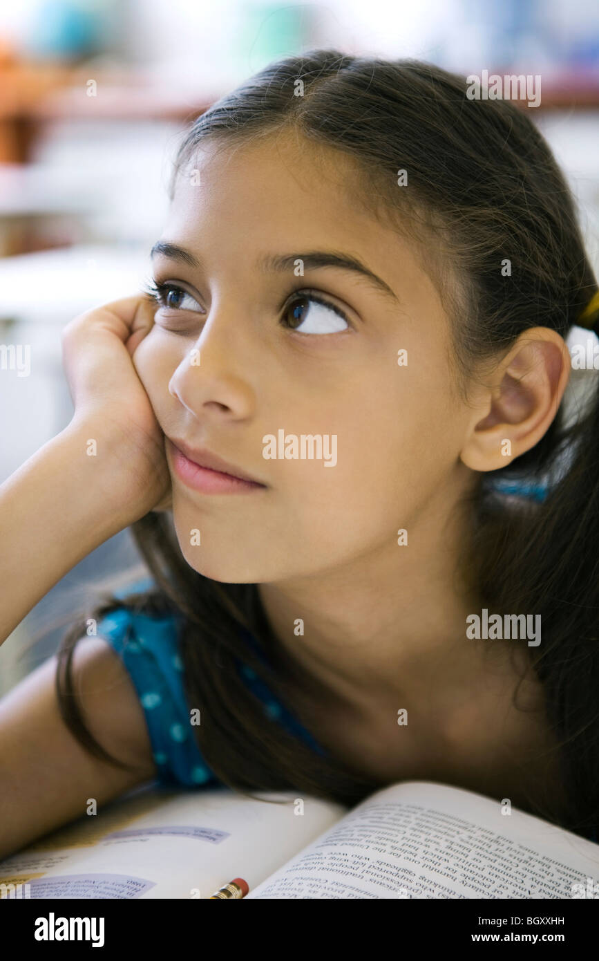 Female elementary school student daydreaming in class Stock Photo - Alamy