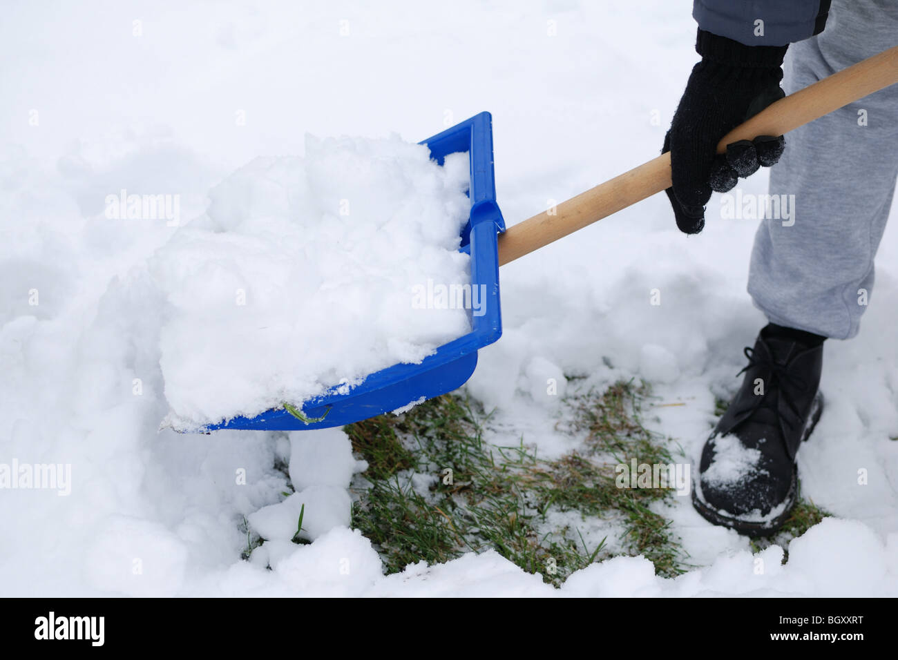 Man plowing snow in his garden with shovel Stock Photo - Alamy