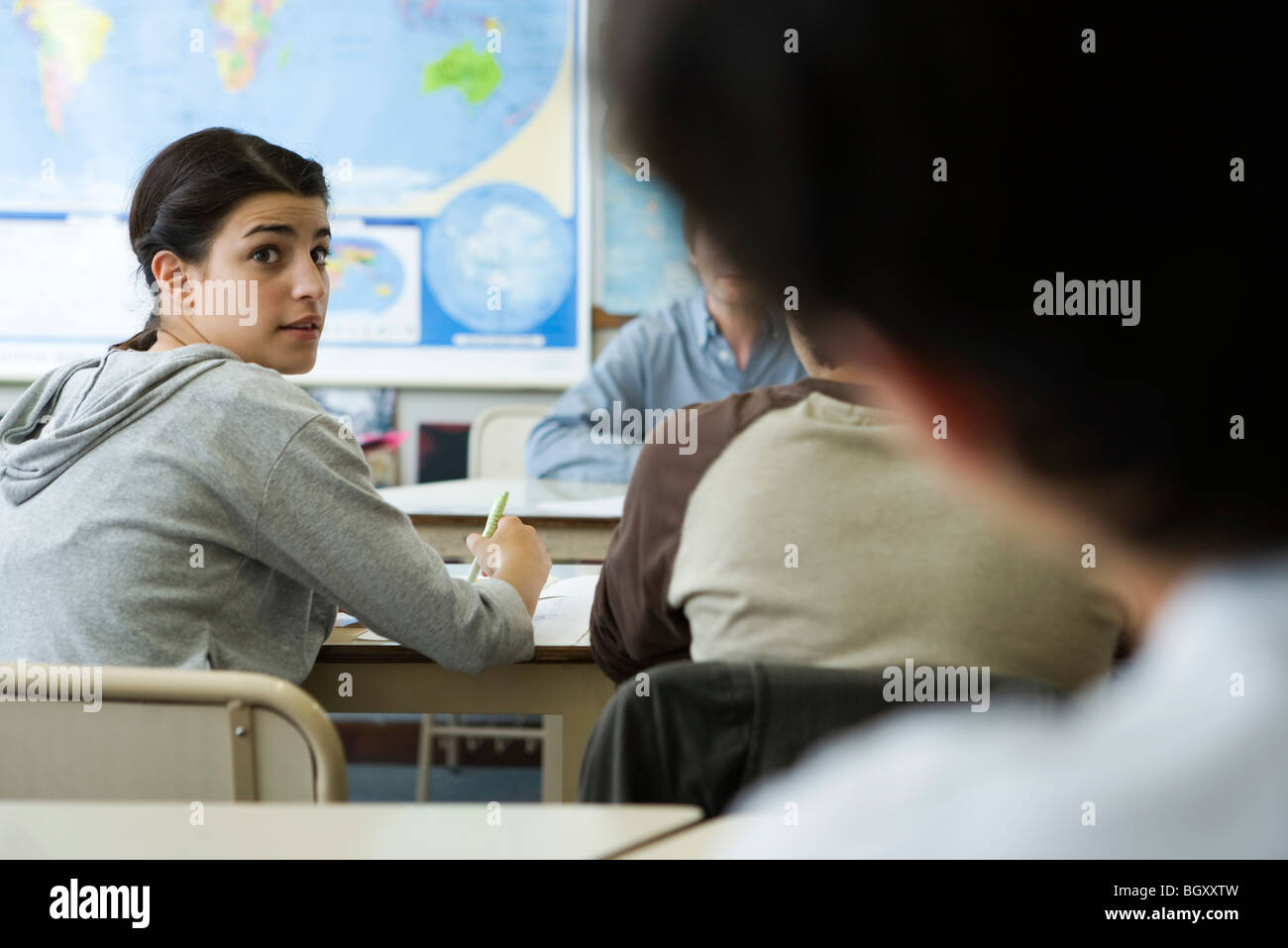 Female high school student looking over shoulder at classmate Stock ...