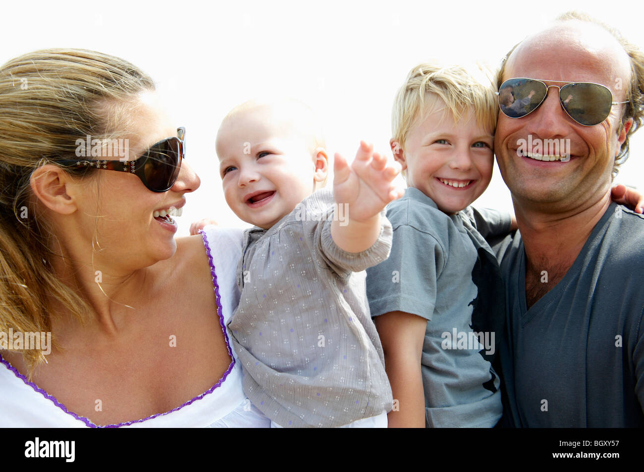 Happy family smiling at camera Stock Photo - Alamy