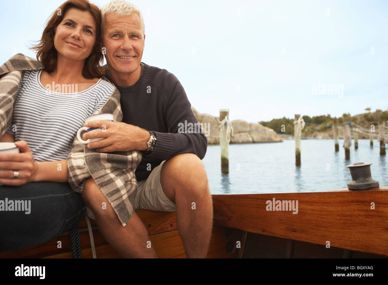 Middle aged couple cuddling on old boat Stock Photo - Alamy