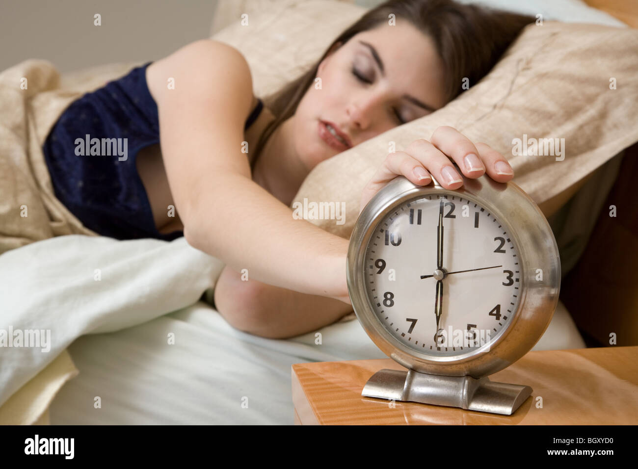 Woman in early waking up to an alarm clock Stock Photo - Alamy