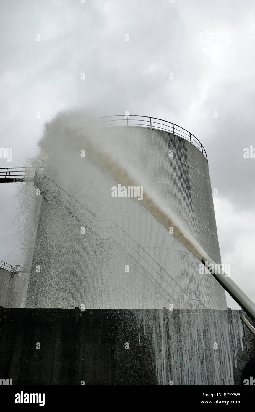Fire Brigade spraying high expansion foam onto oil storage tank at ...
