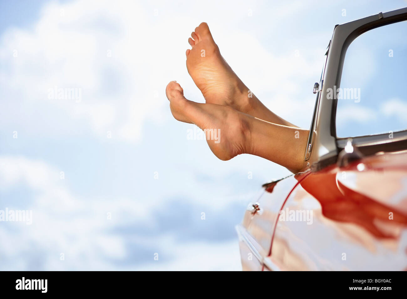 Woman's feet sticking out of car window Stock Photo - Alamy
