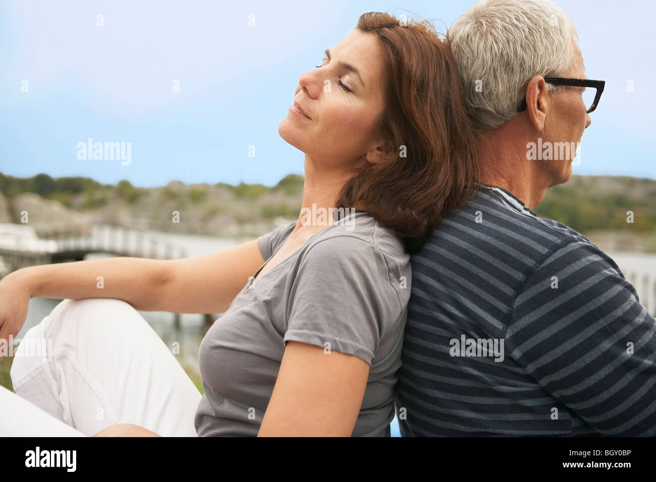 Middle aged couple, back to back Stock Photo - Alamy