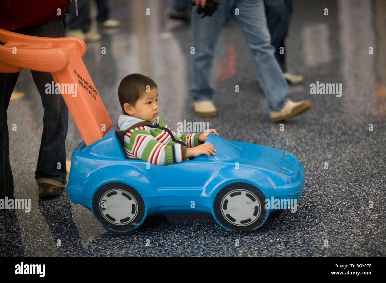 A young visitor rides in a toy car at The Los Angeles Auto Show 2009 ...