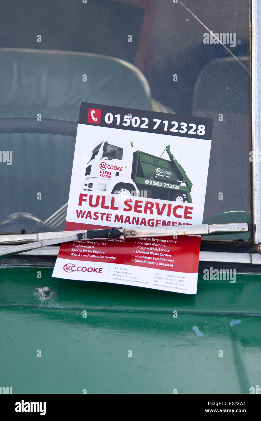 A flyer advertising full service waste management on a car windscreen ...