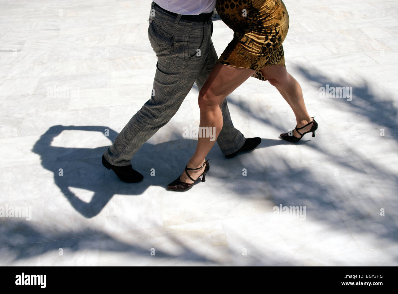 legs of a Couple dancing Tango outside on marble surface in the ...