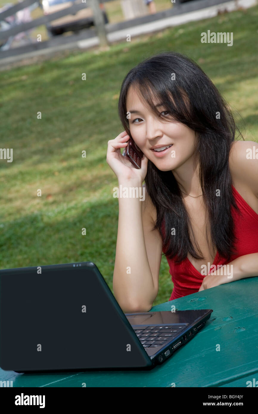 Beautiful Asian student studying using a computer at a park Stock Photo ...