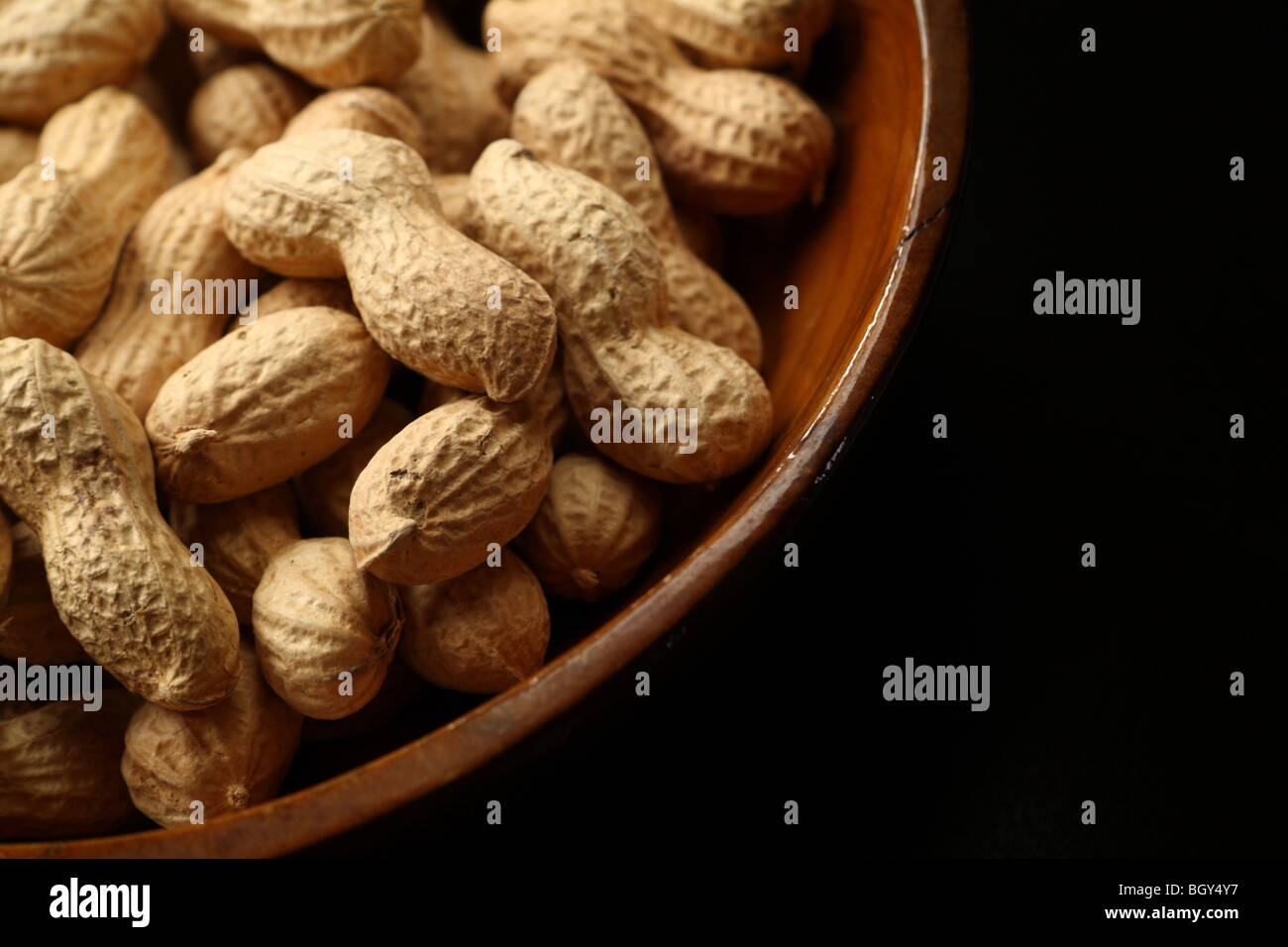 Peanuts inside a old wood bowl isolated on black background Stock Photo ...