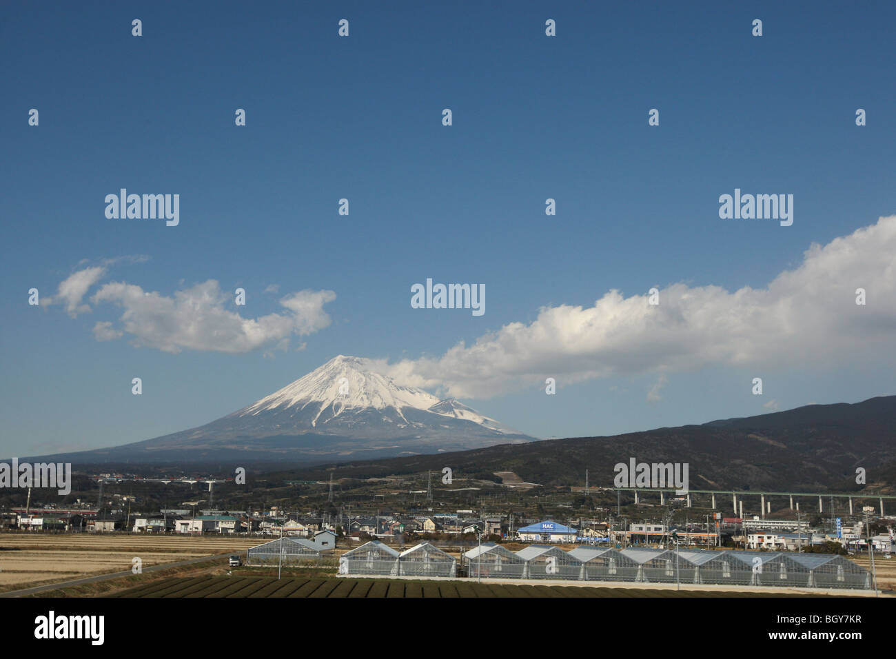 Mount Fuji, seen behind a backdrop of agricultural and industrial ...