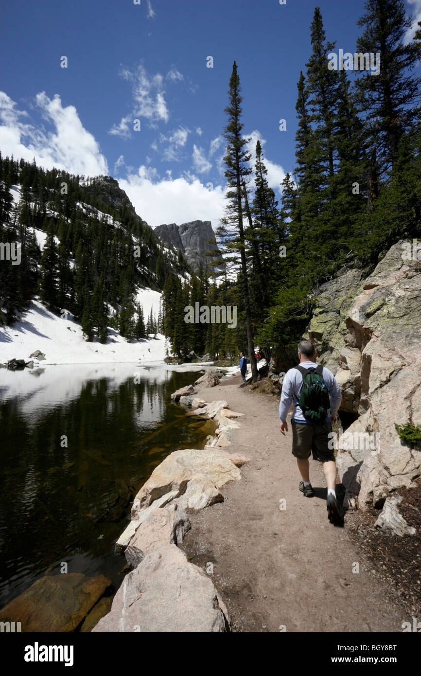 Hikers on trail running alongside the edge of Nymph Lake, Rocky ...