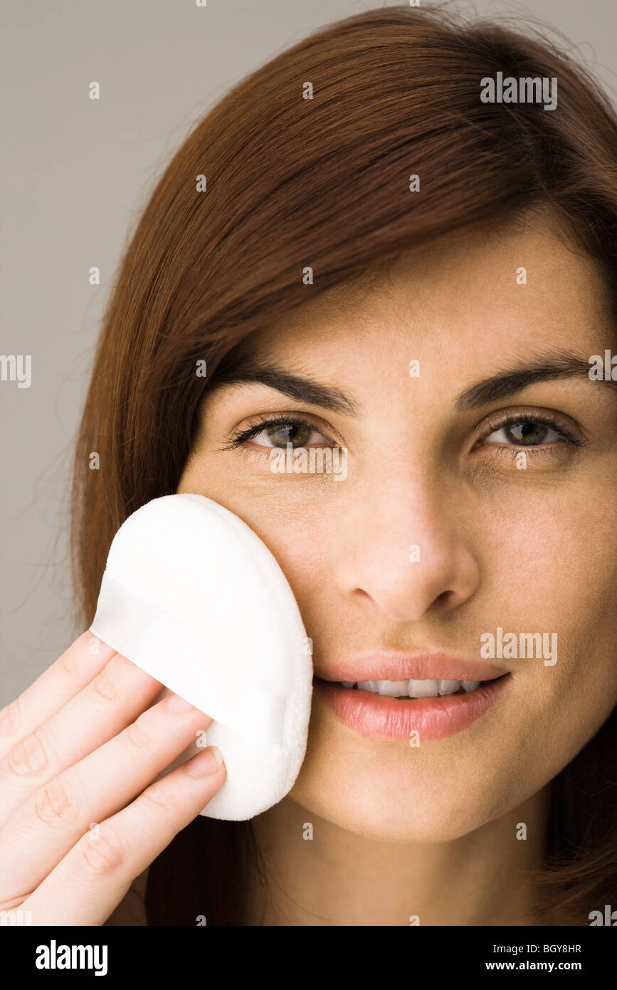 Young woman applying facial powder Stock Photo - Alamy