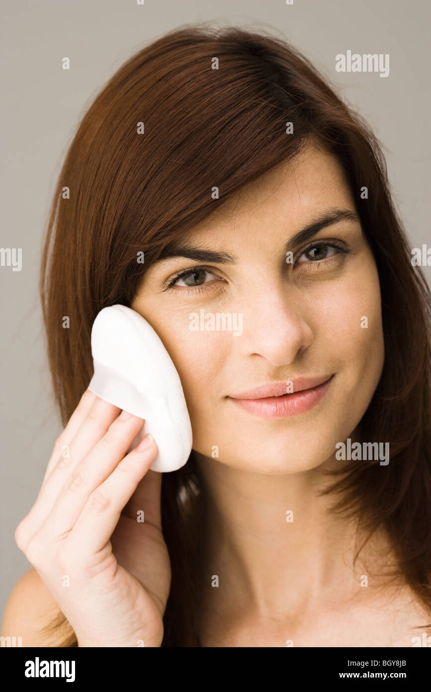 Young woman applying facial powder Stock Photo - Alamy