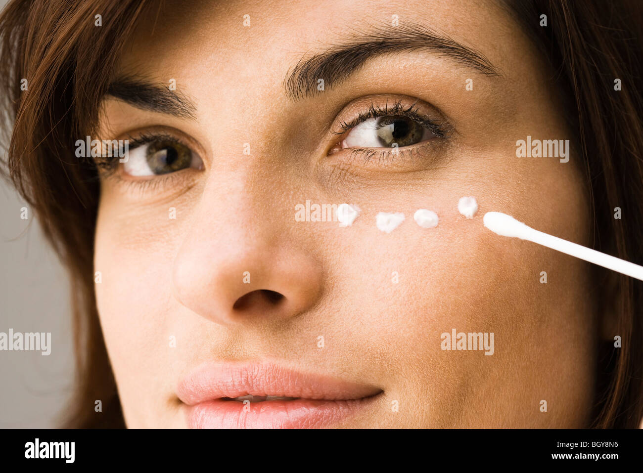Young woman applying undereye cream Stock Photo - Alamy