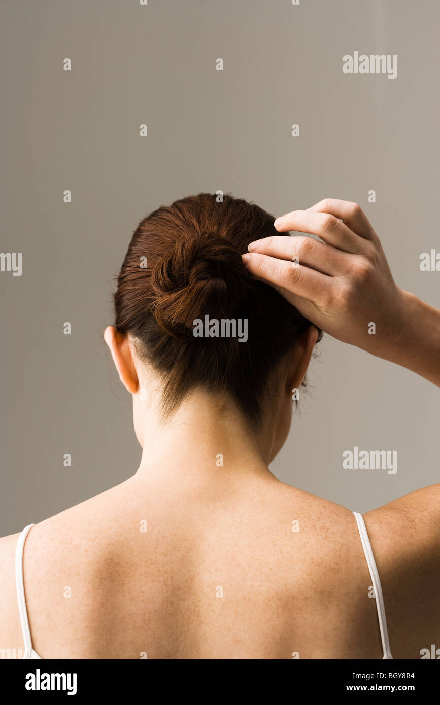 Woman styling hair, rear view Stock Photo - Alamy