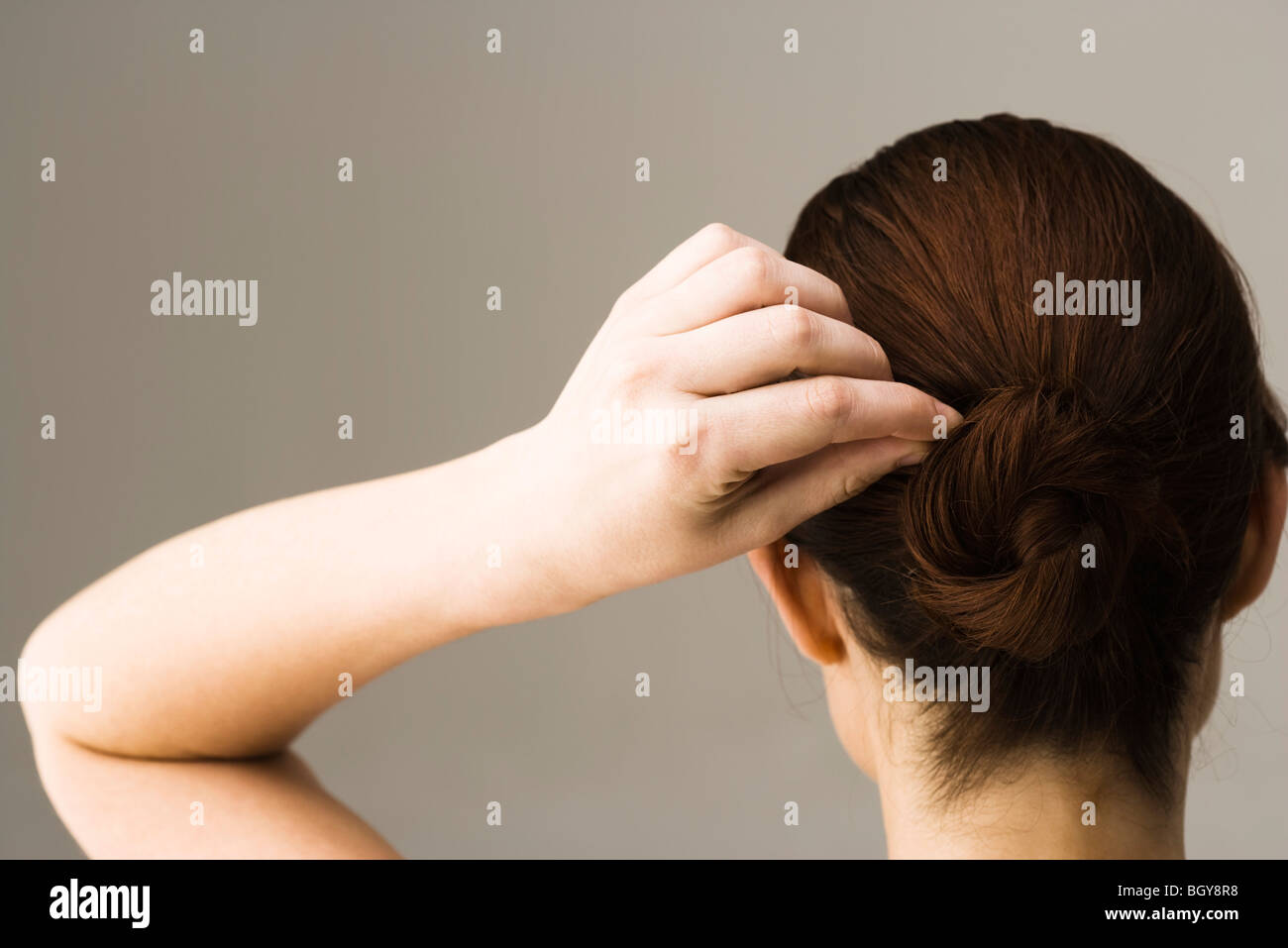 Woman styling hair, rear view Stock Photo - Alamy