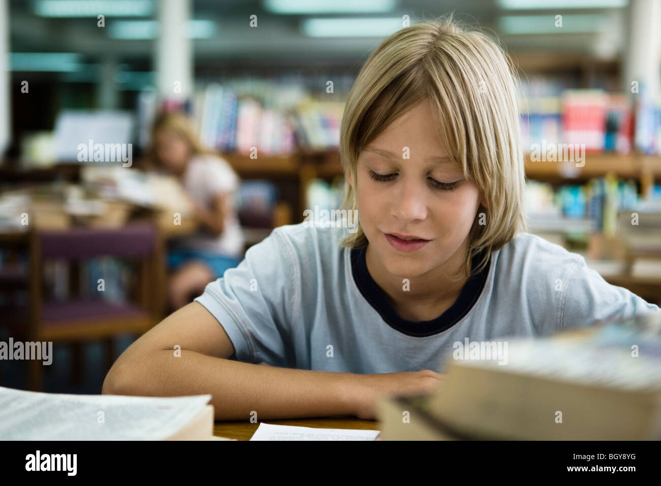 Boy reading in library Stock Photo - Alamy