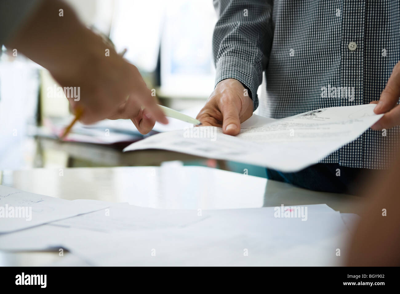 Colleagues reviewing document together Stock Photo - Alamy