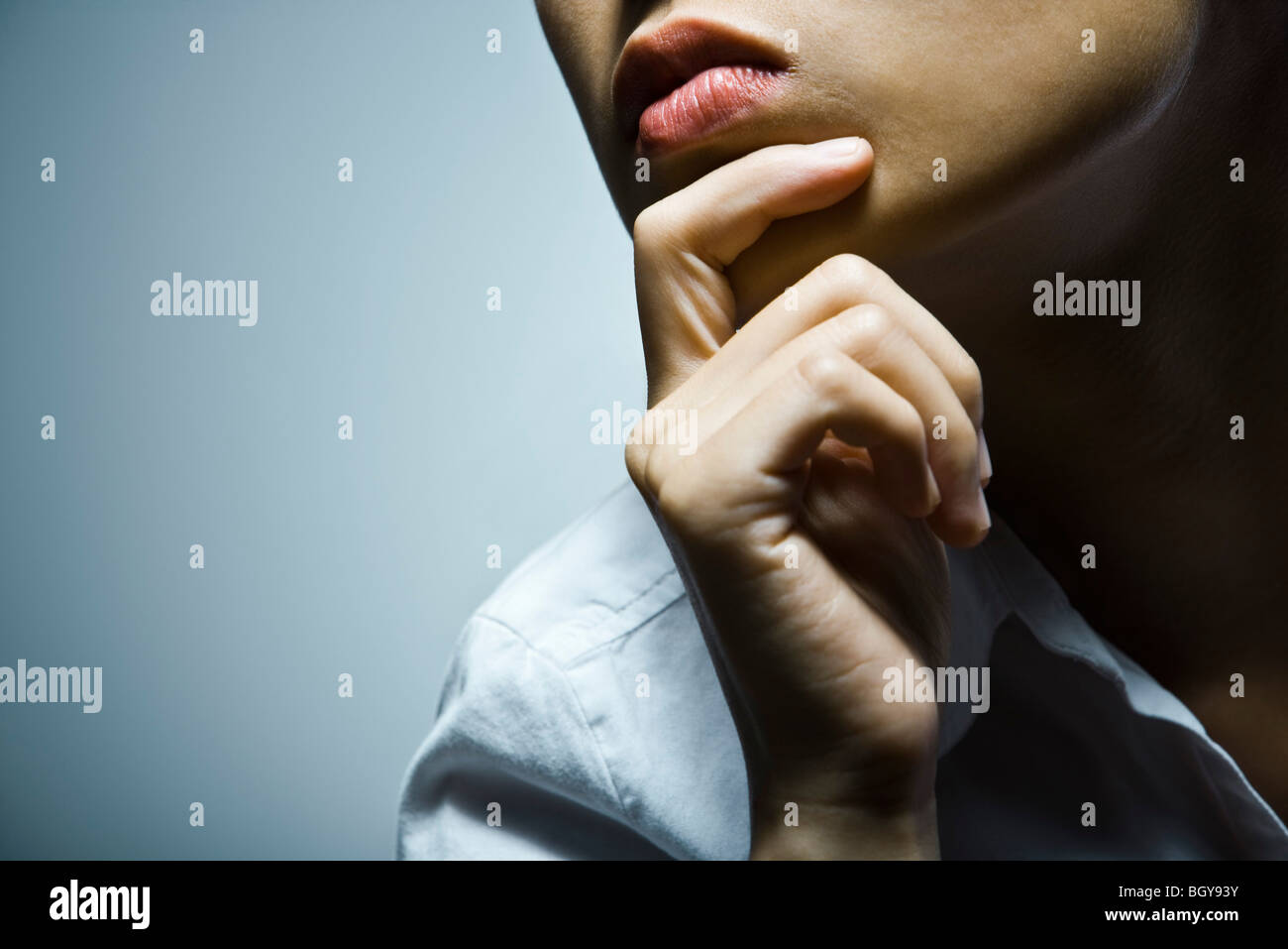 Young woman with hand under chin, cropped Stock Photo - Alamy