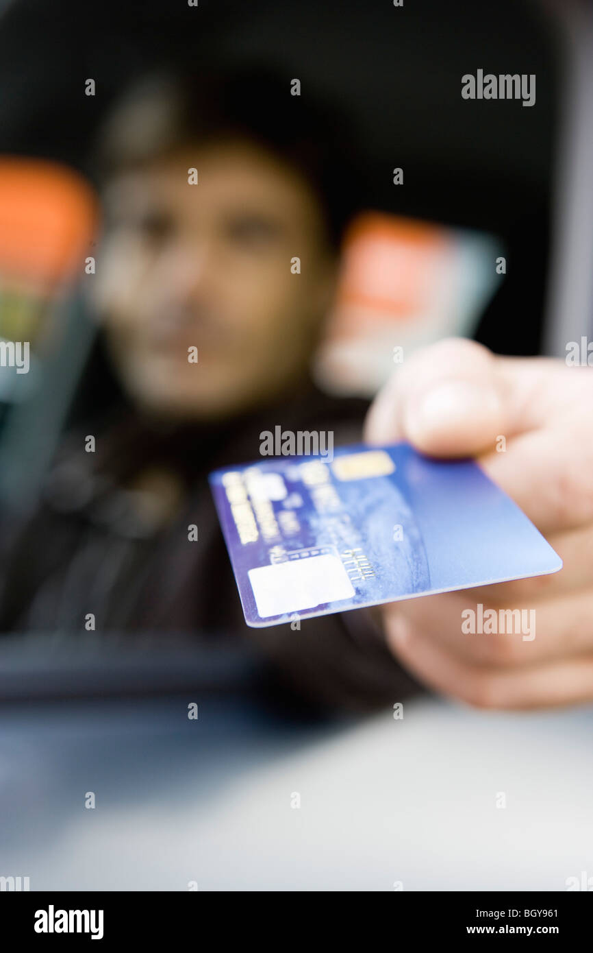Customer in drive-thru holding out credit card Stock Photo - Alamy