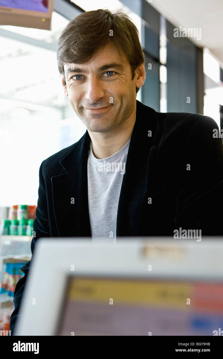 Customer waiting at checkout counter Stock Photo - Alamy